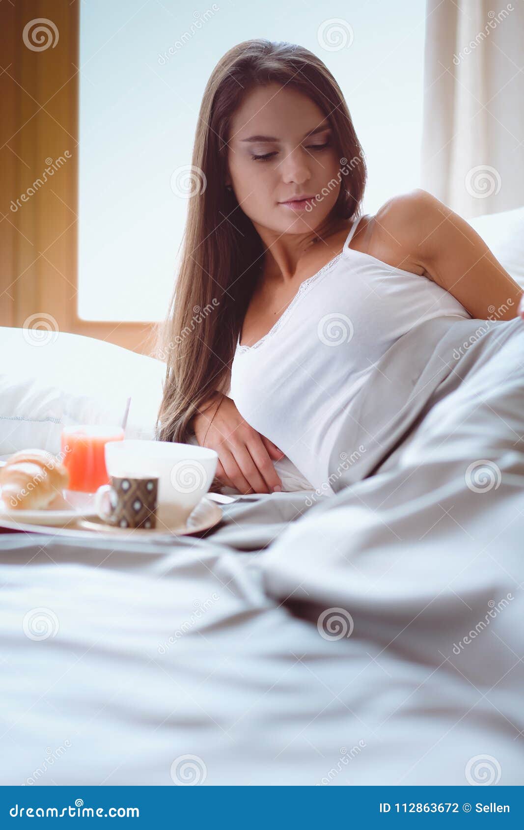 Jonge Vrouwenzitting In Bed Met Een Kop Van Melk Stock Foto Image Of