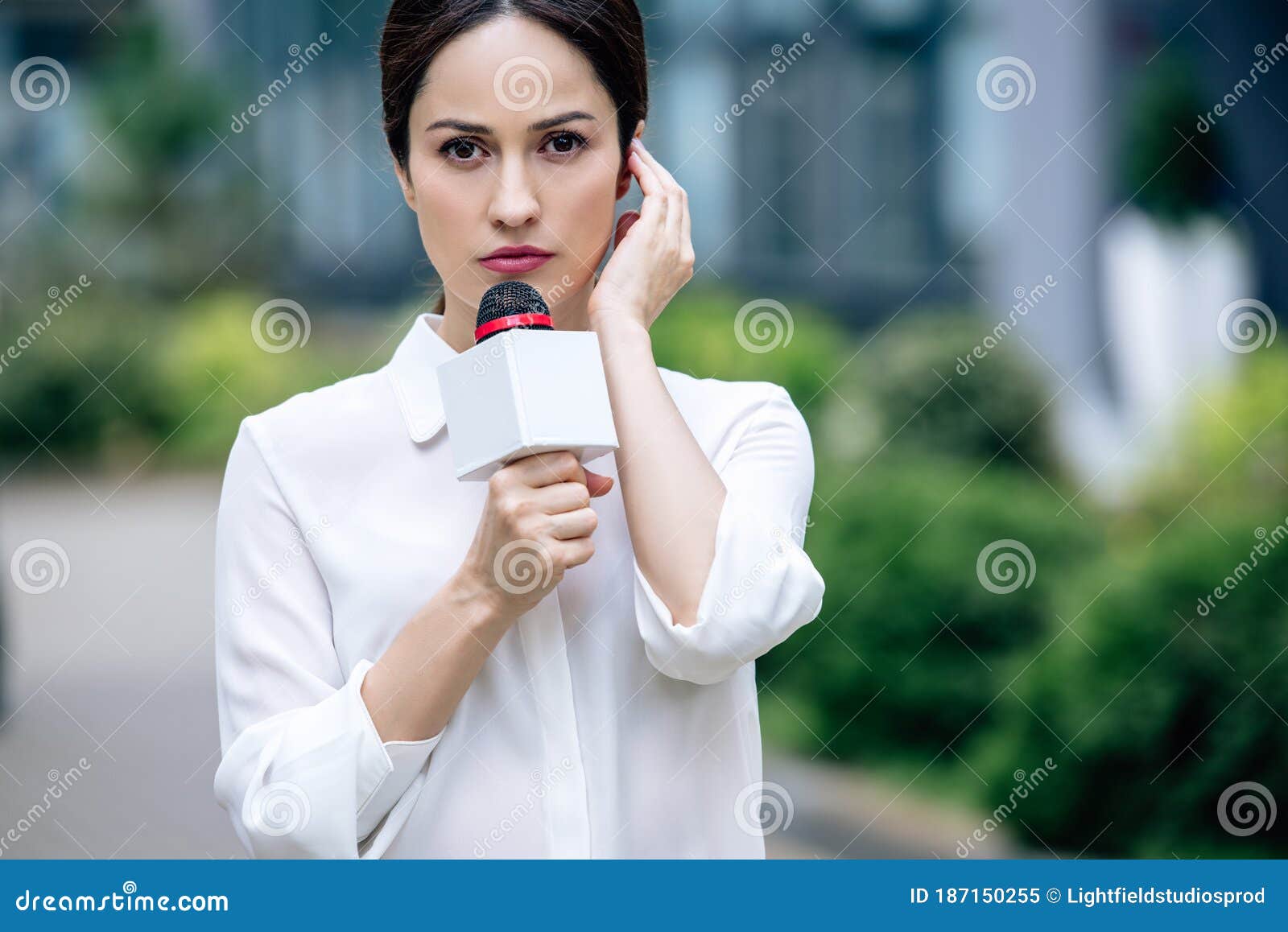 Journalist in Formal Wear Holding Microphone and Looking at Camera ...