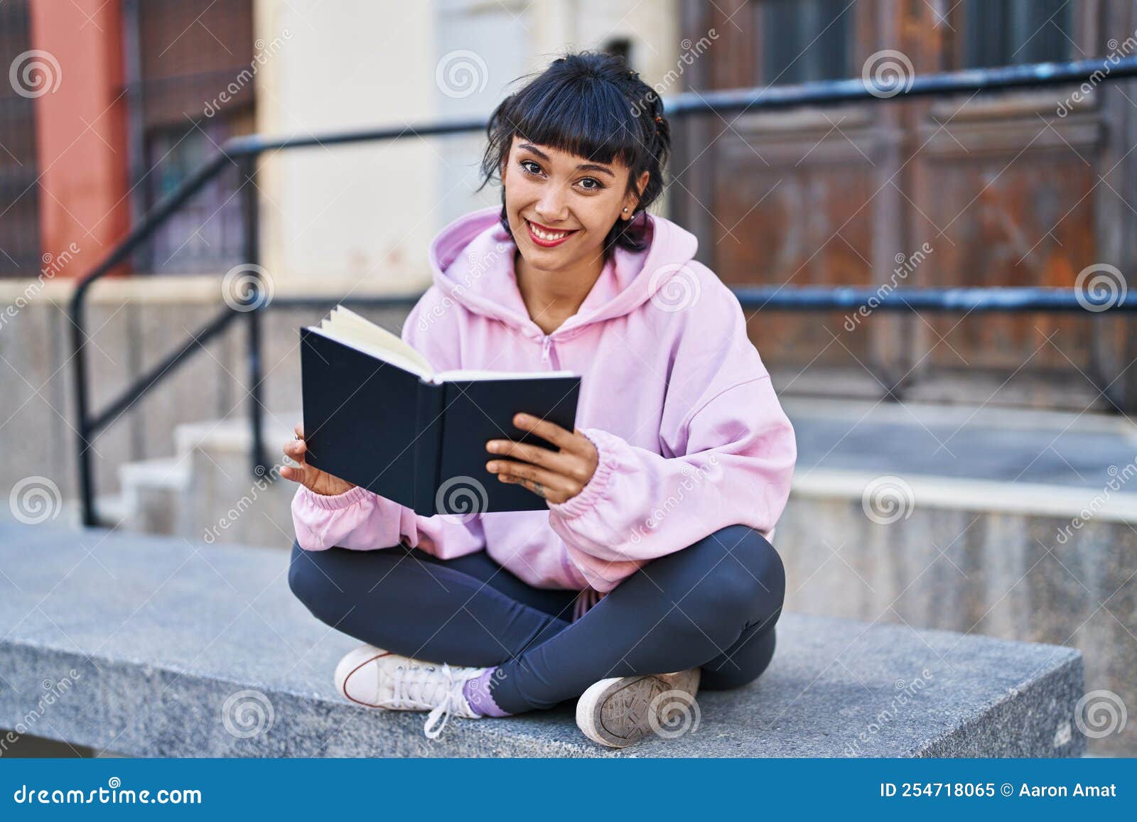 Joven Leyendo Un Libro Sentado En Un Banco En La Calle Imagen de ... Joven Leyendo Un Libro Sentado En Un Banco En La Calle Imagen de ...