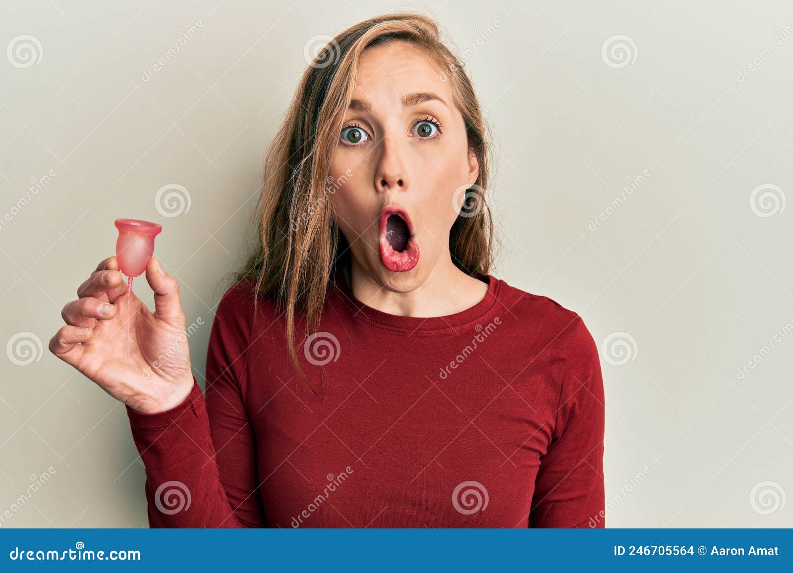 Joven Rubia Sosteniendo Una Taza Menstrual Asustada Y Asombrada Con La