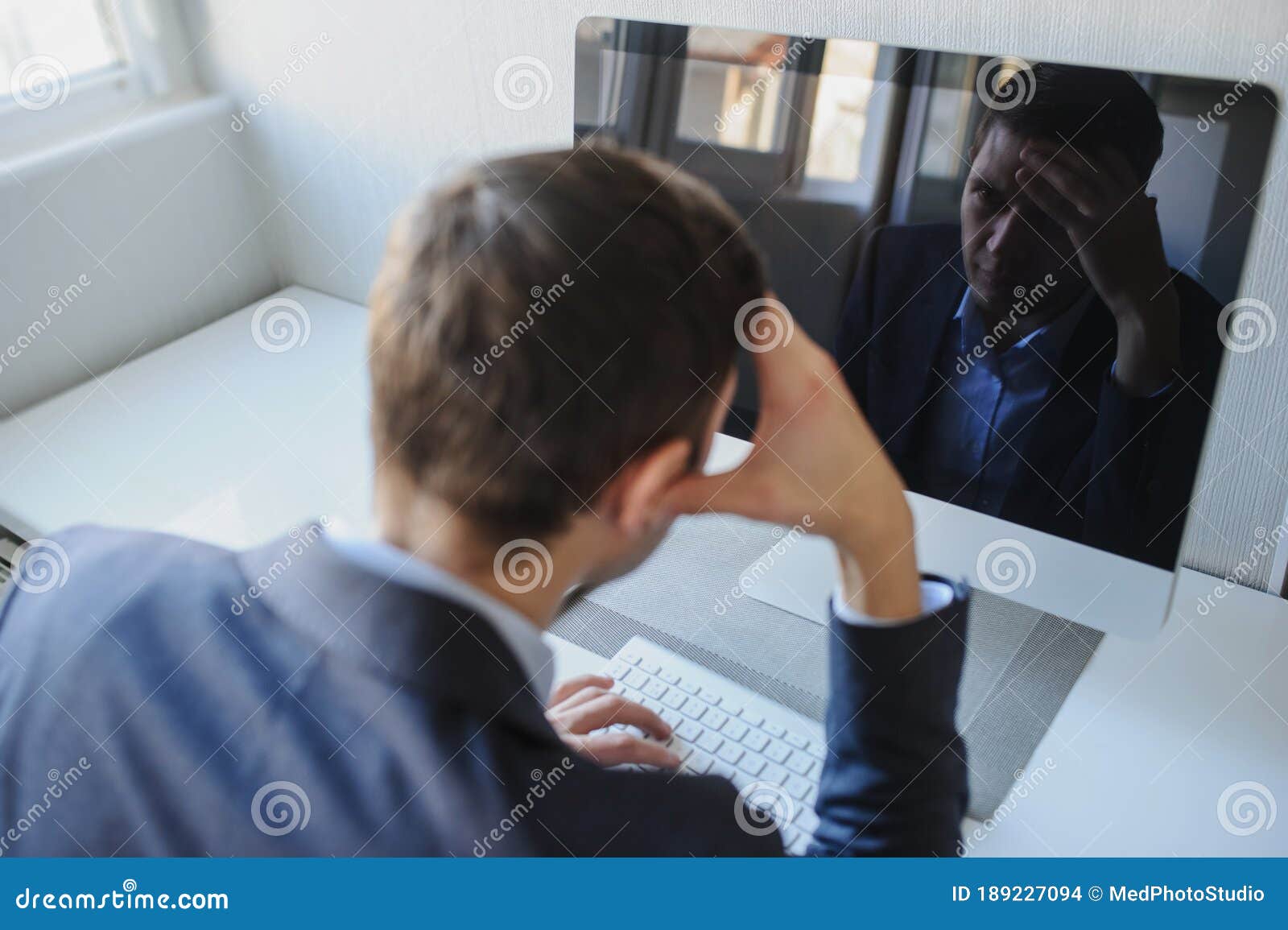 Joven Sentado Frente a Un Monitor De Computadora Y Pensando En Una ... Joven Sentado Frente a Un Monitor De Computadora Y Pensando En Una ...