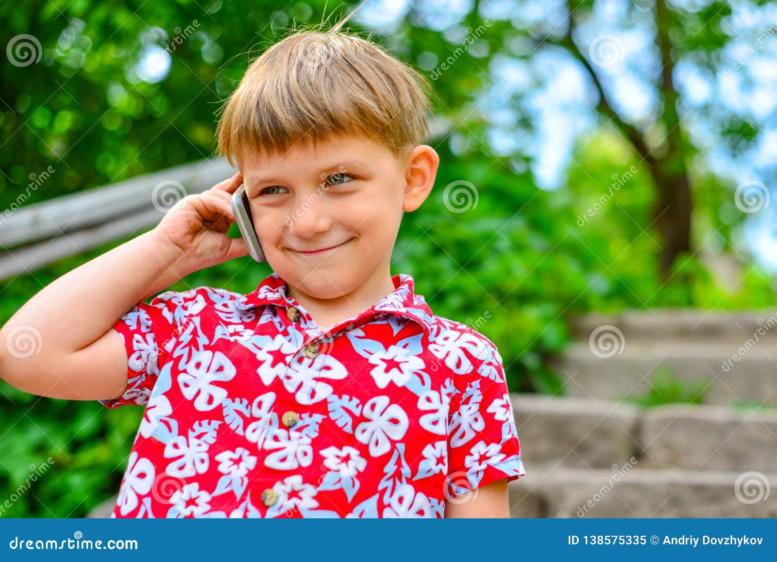 Joyful Boy Talking on the Phone while Standing in the Park on the Steps ...