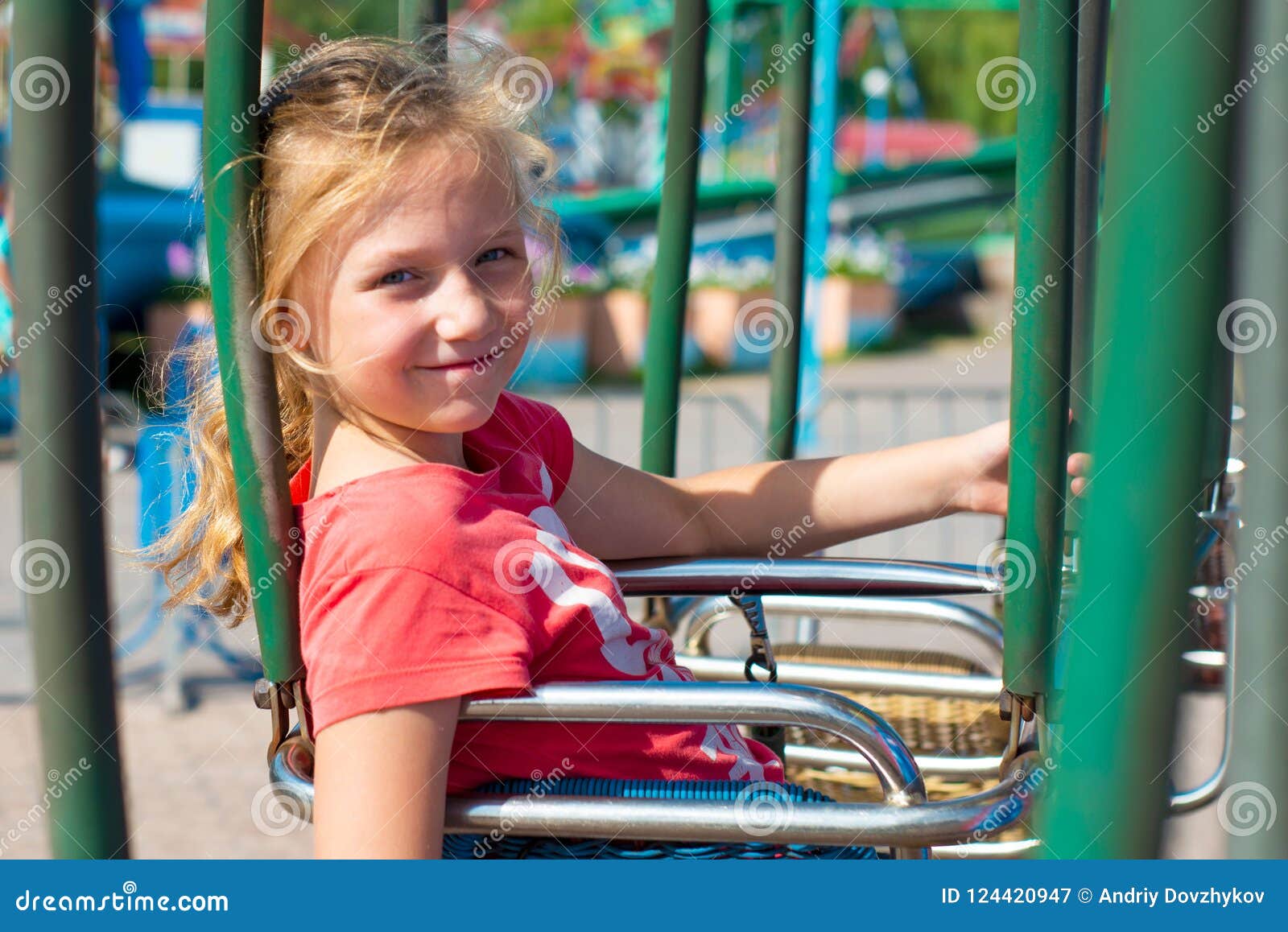 Joyful Girl Rides on a Carousel and Looks at the Camera. Stock Image ...