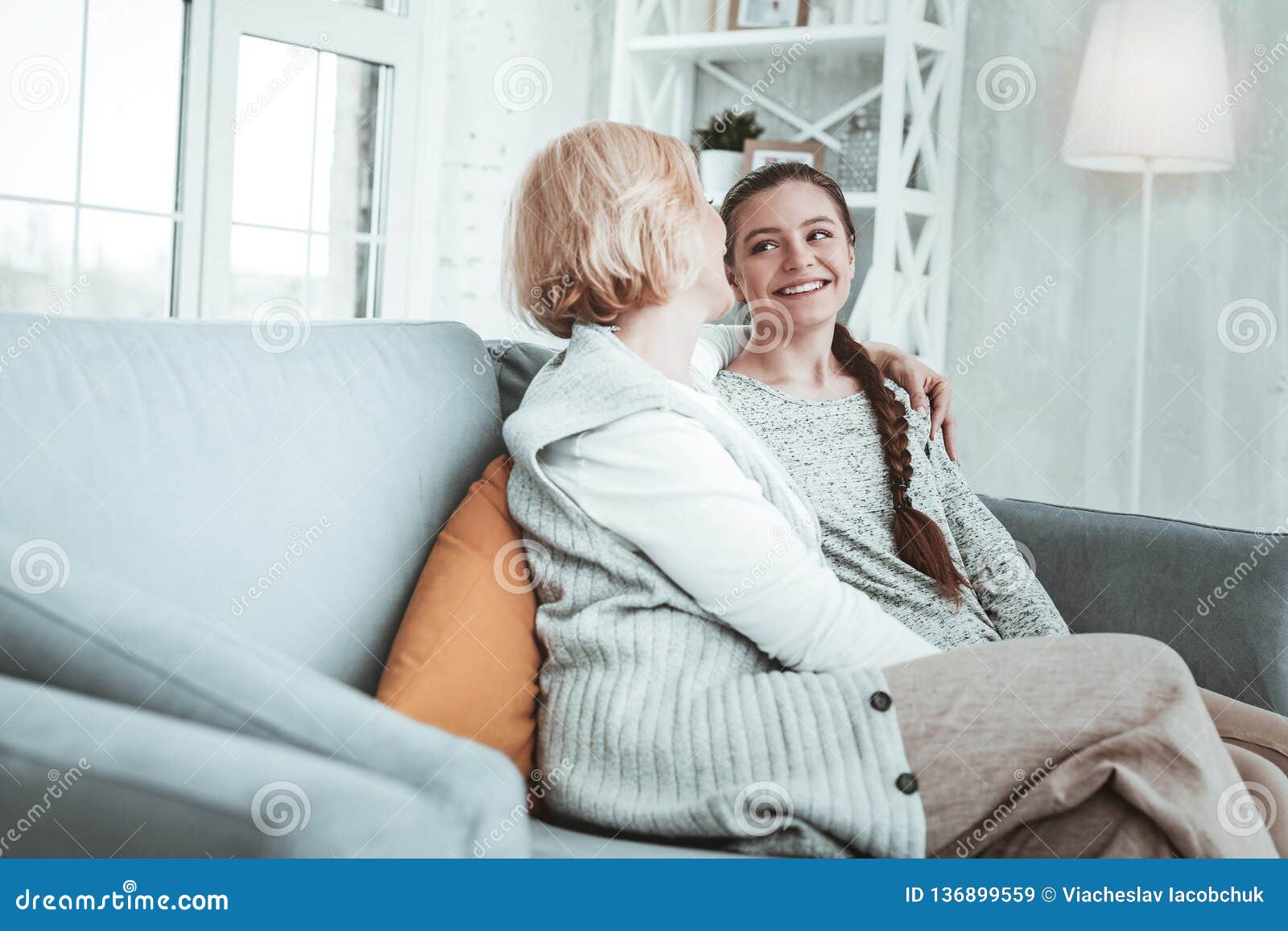 Joyful Happy Girl And Her Grandmother Sitting On The Sofa Stock Image