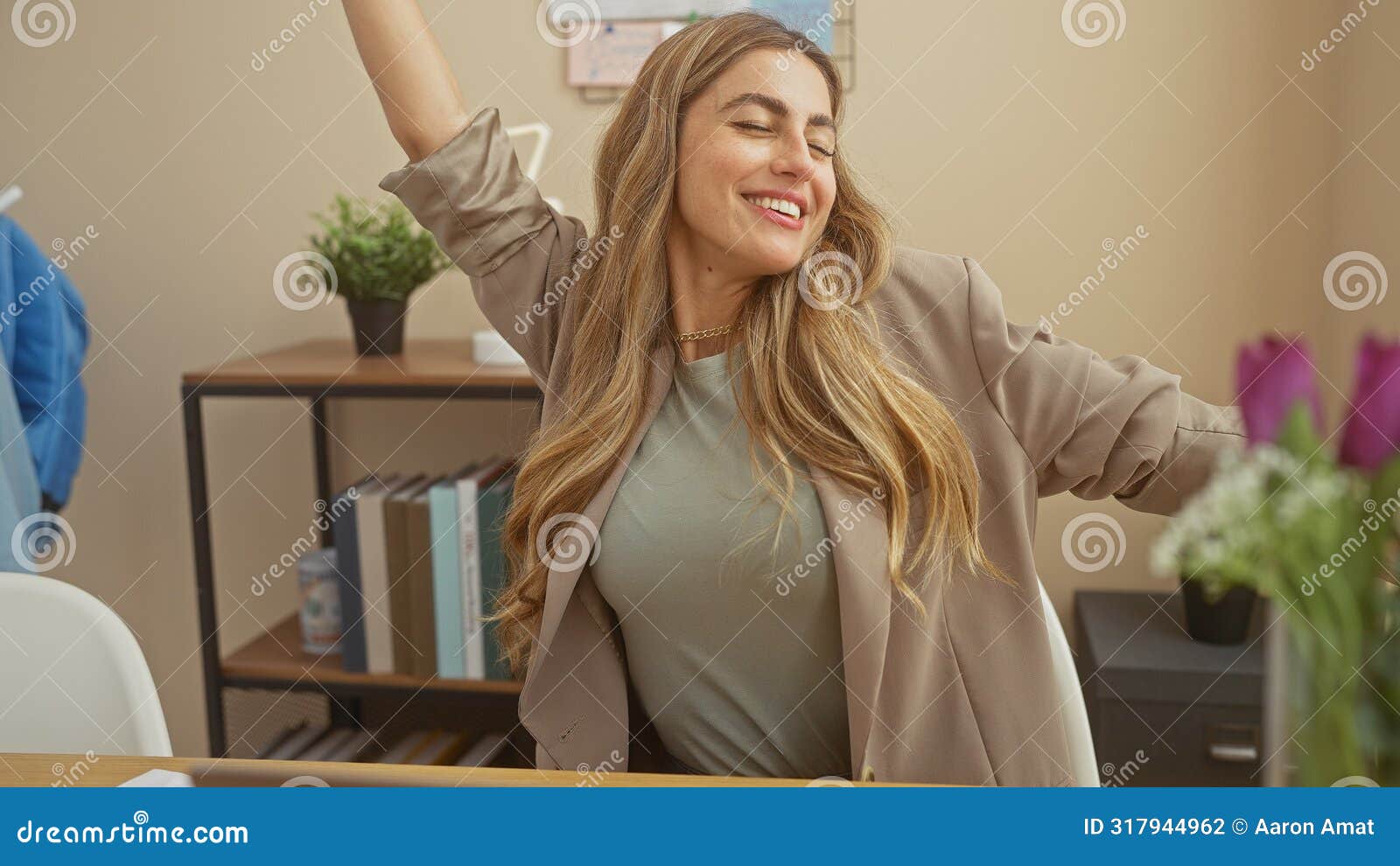 Joyful Woman Stretching in a Modern Office during a Break, Evoking ...