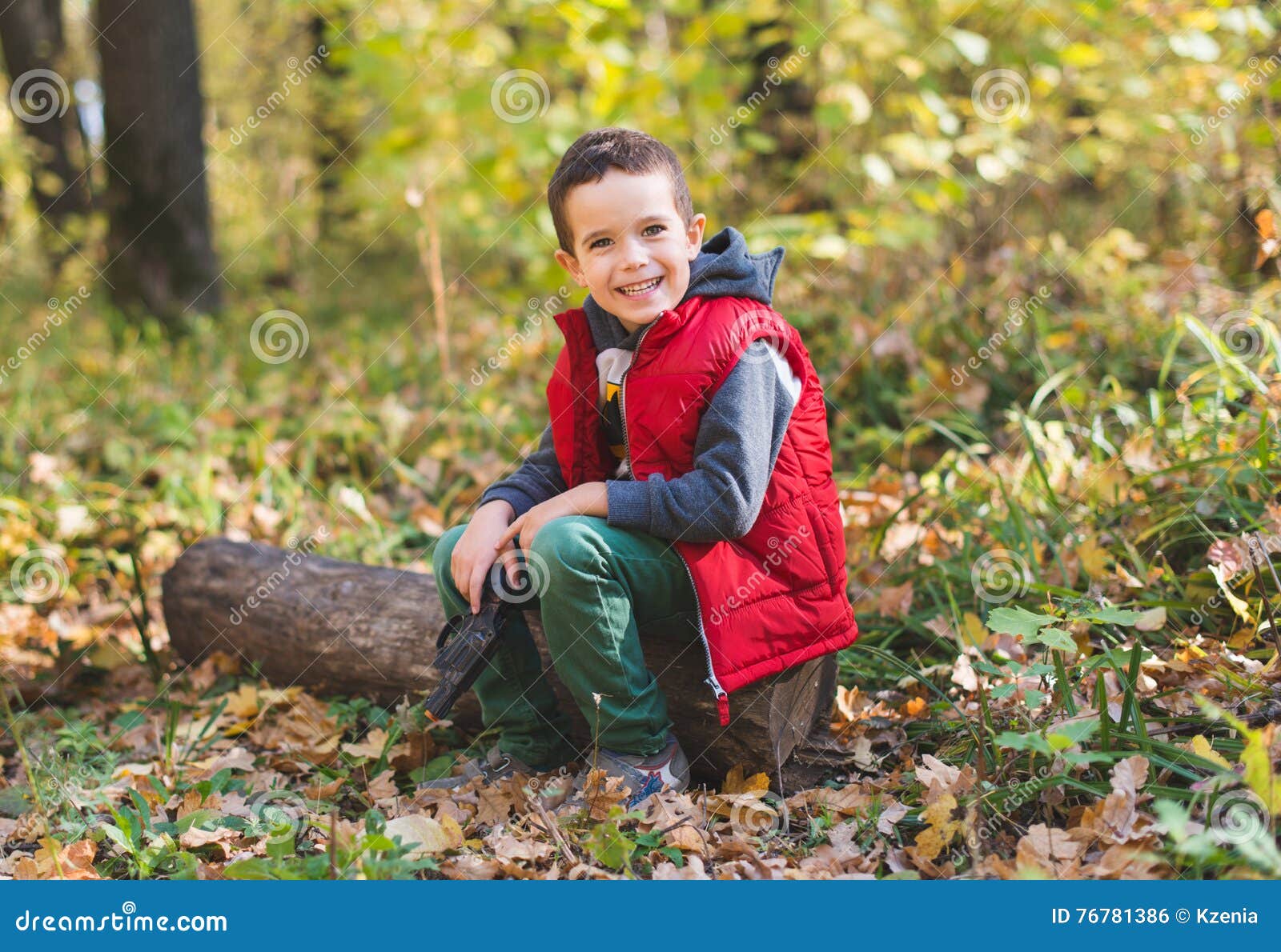 Joyfull Boy Sitting on Log in the Forest Stock Photo - Image of ...