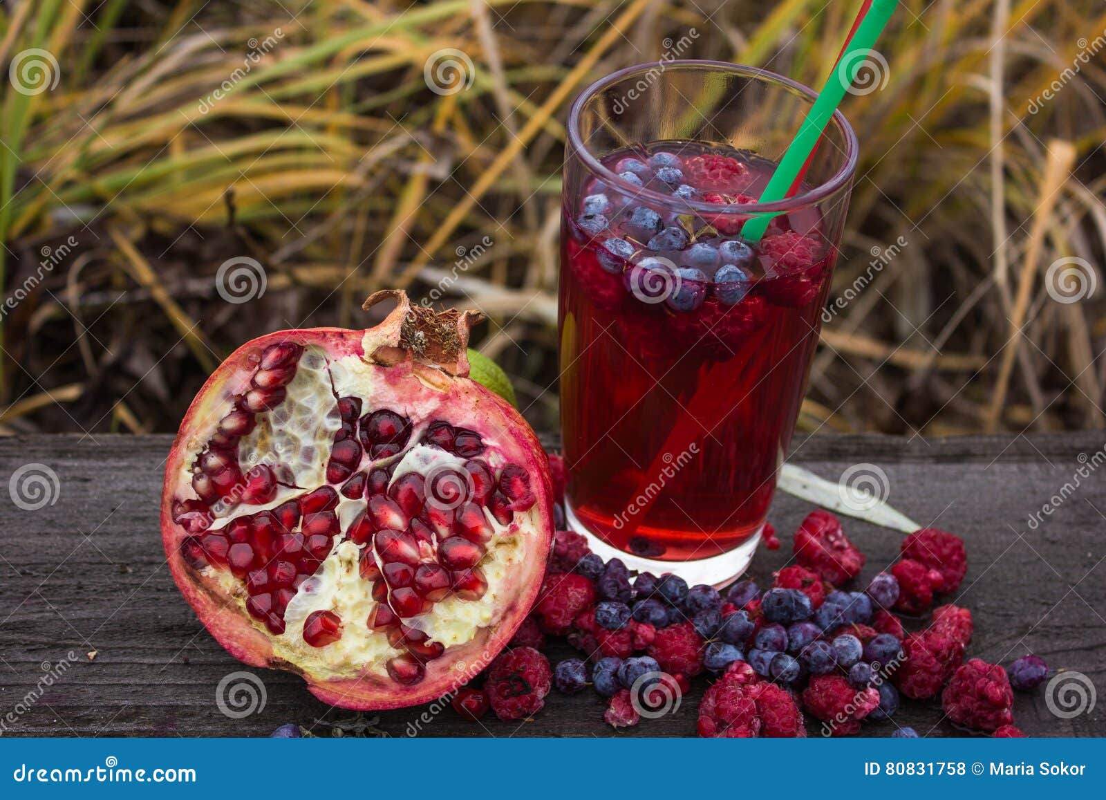 Juice Large Ripe Pomegranate and Raspberry on a Wooden Background Stock ...