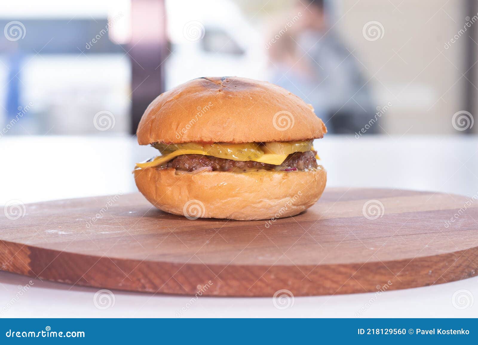 Juicy Cheeseburger on a Wooden Plate on a Table in a Restaurant. Stock ...