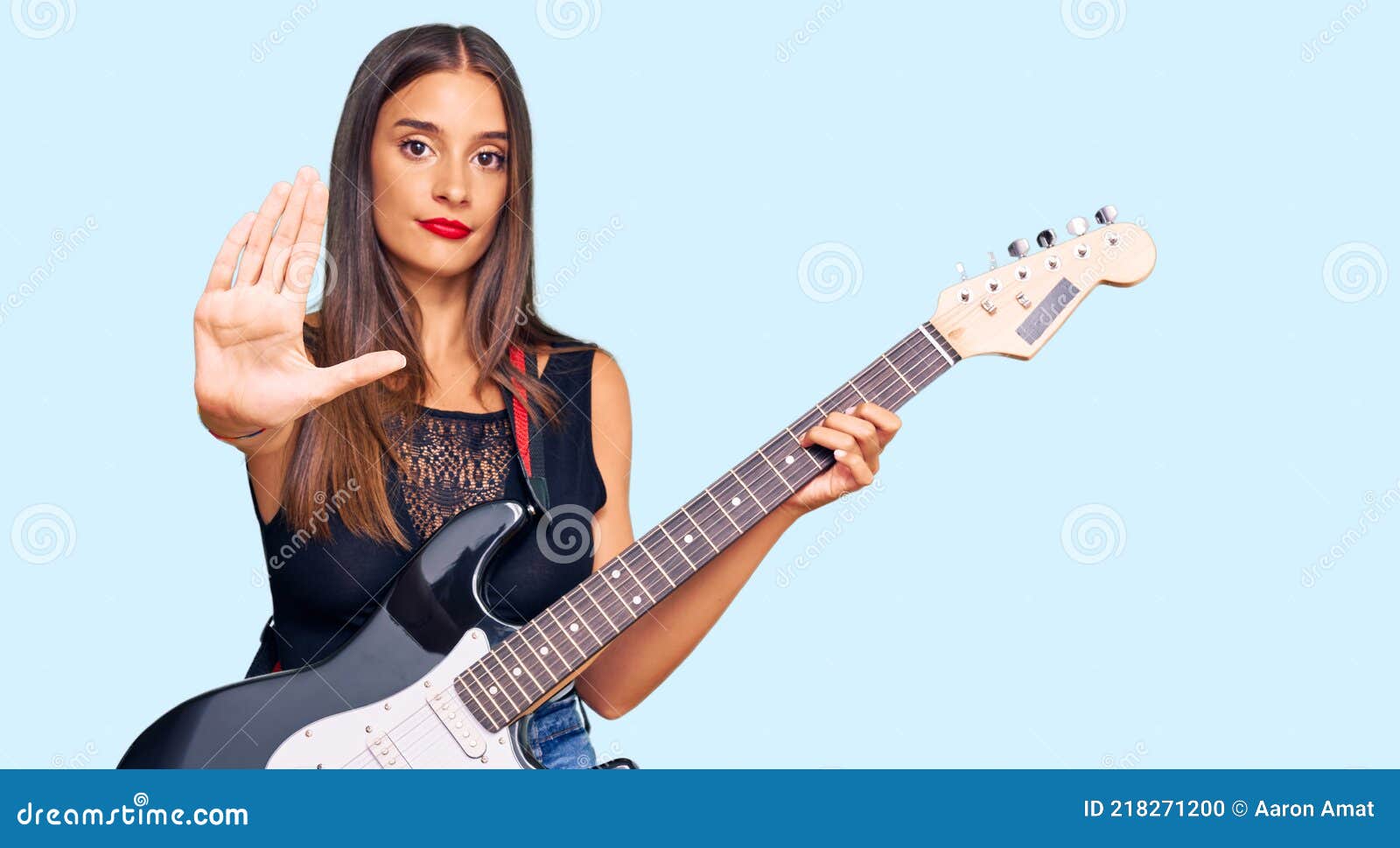 Junge Hispanische Frau Spielen E-Gitarre Mit Offener Hand Tun Stopp ... Junge Hispanische Frau Spielen E-Gitarre Mit Offener Hand Tun Stopp ...