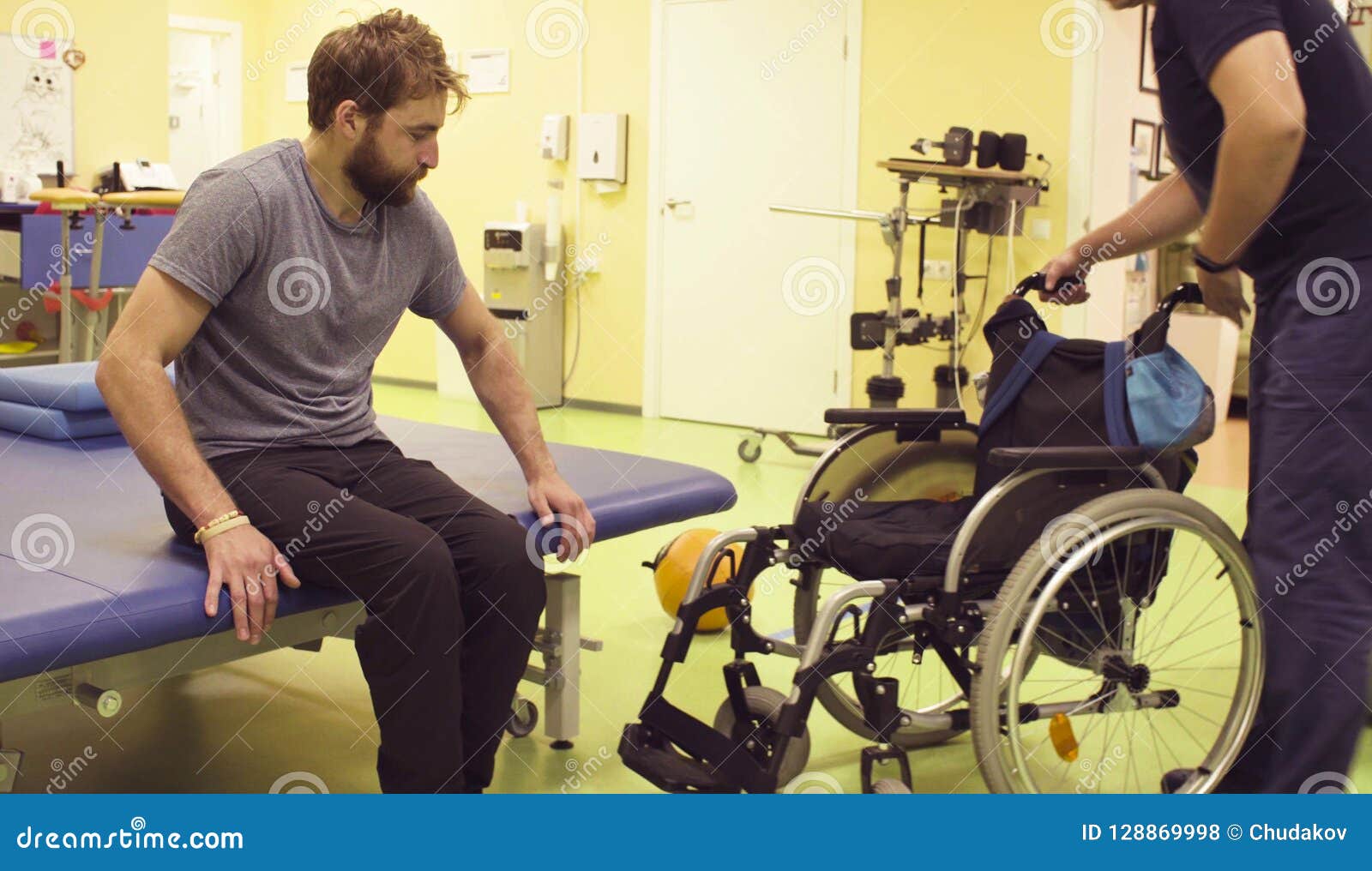 Junger Behinderter Mann, Der Geht, Sich in Einem Rollstuhl Hinzusetzen ...