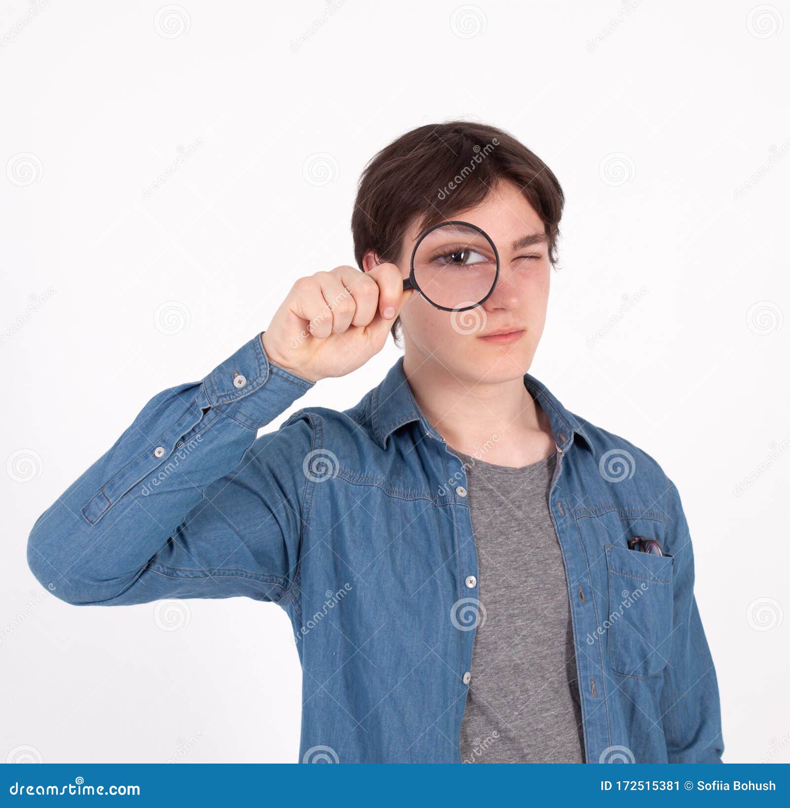 Junger Mann Mit Lupe Auf Grauem Hintergrund Neugieriger Junger Mann Mit ...