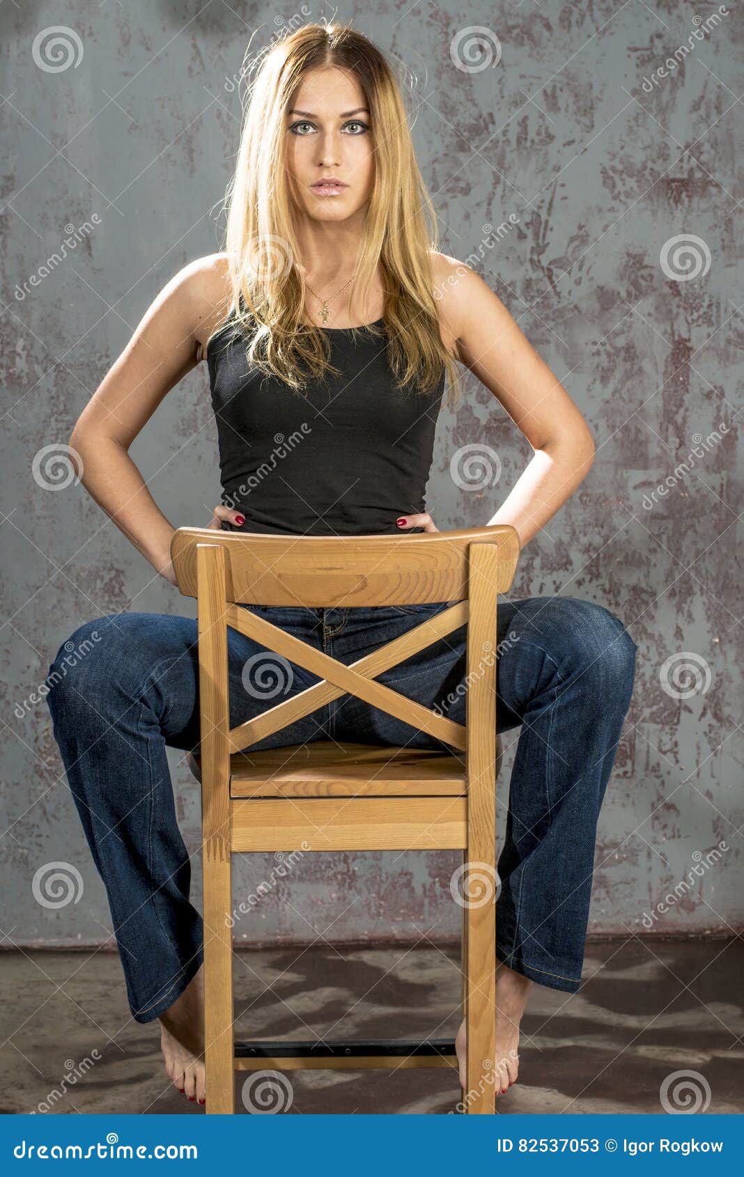 Junges Schlankes Blondes Mädchen In Den Jeans Und In Hemd Die Kokett