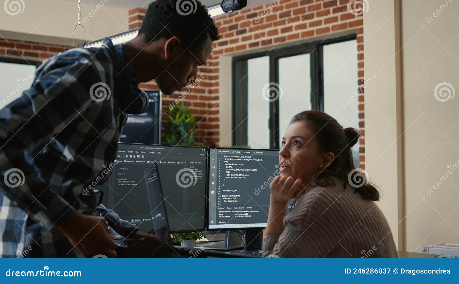 Junior Developer Sitting Down on Desk Showing Laptop with Source Code ...