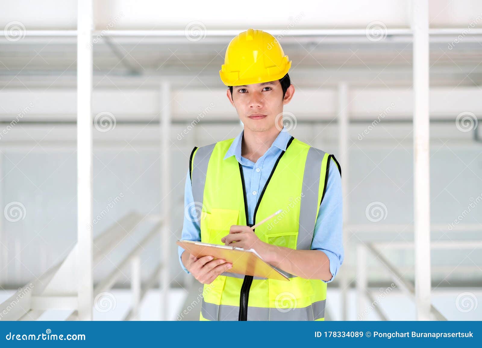 Junior Engineer Standing in the Plant Holding the Clipboard and Pencil ...