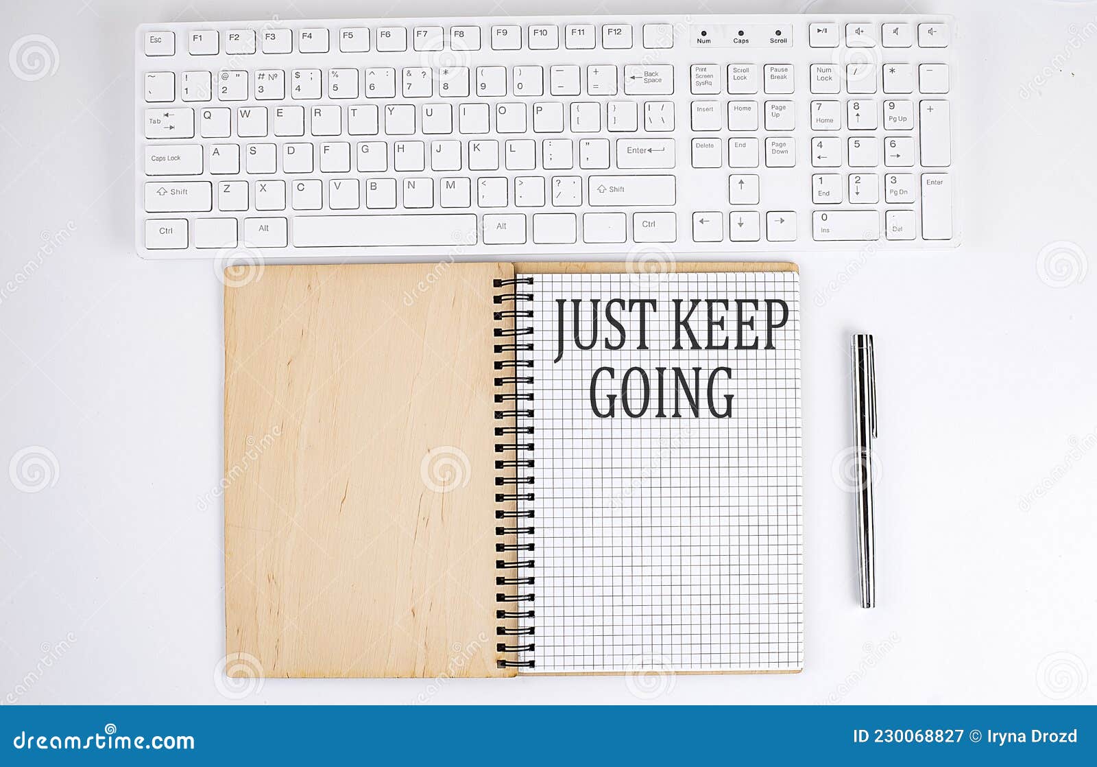 JUST KEEP GOING Text on the Notebook with Keyboard on White Background ...