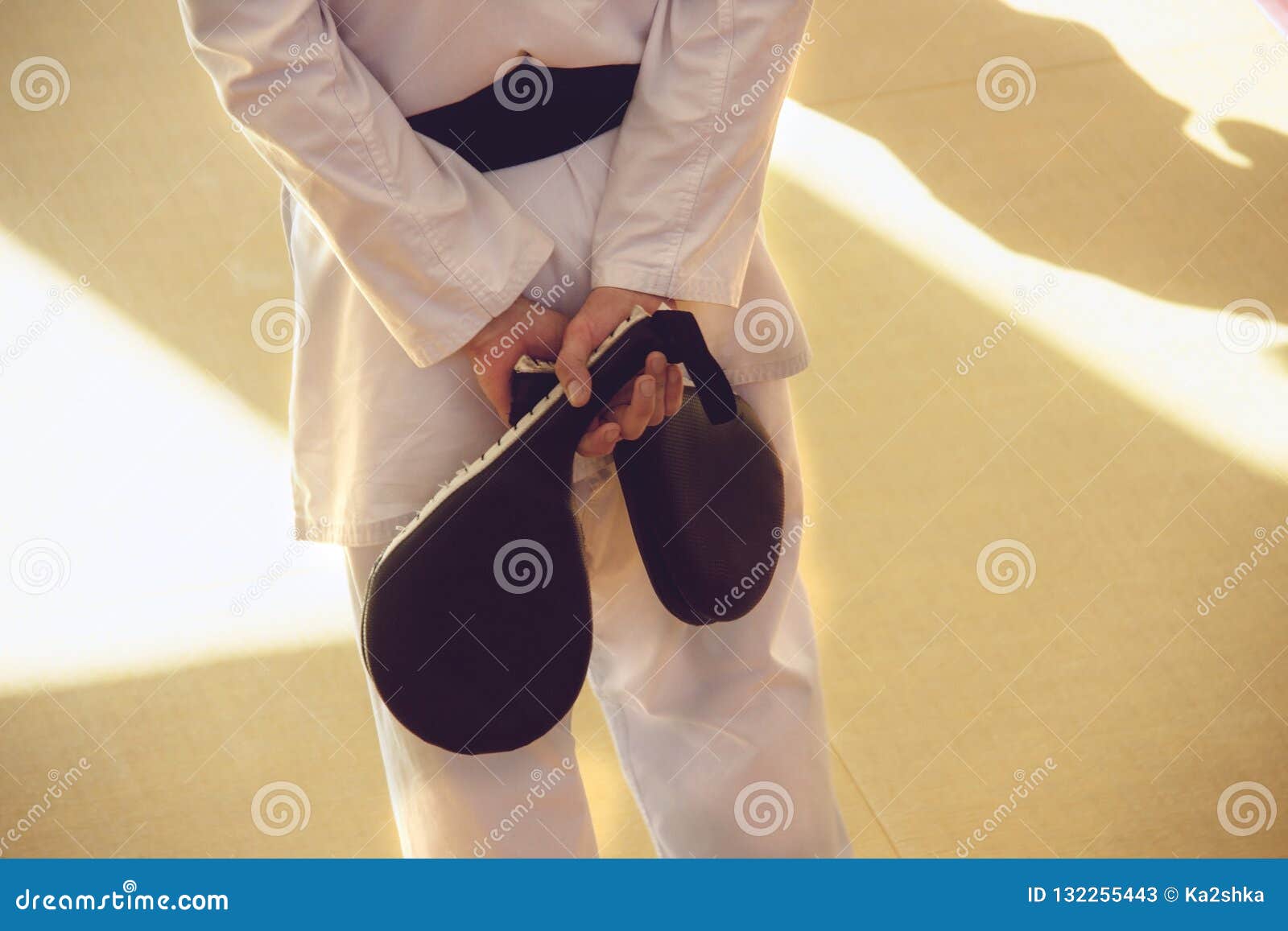 Karate Trainer in Kimono with a Kicking Targets Pad in His Hands in the ...