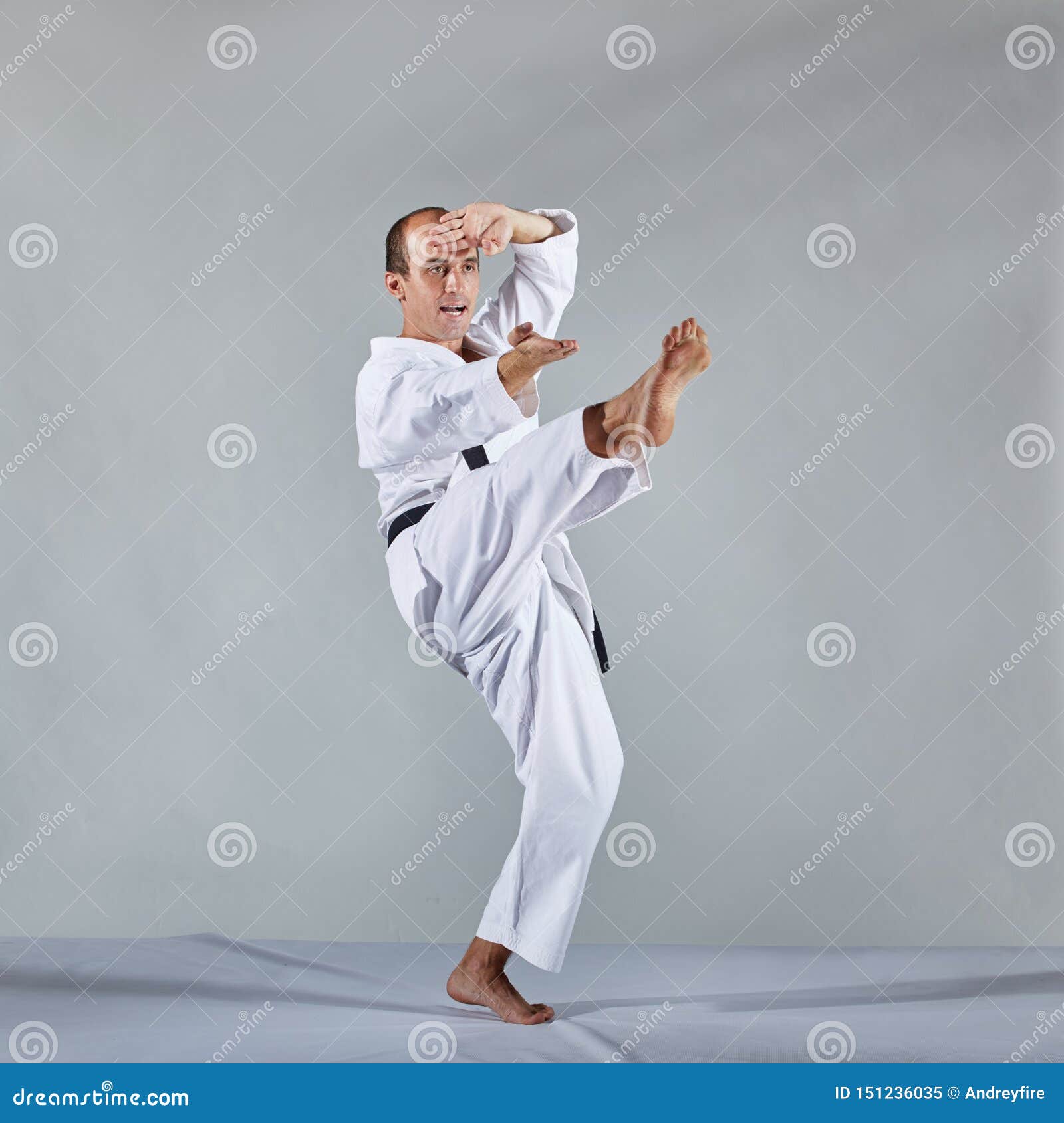 In Karategi, an Athlete Performs Formal Karate Exercises on a Gray ...