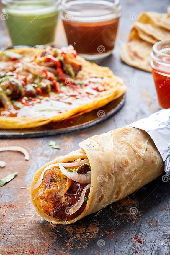 Kati Roll with Meat on a Table Against an Open Roll and Sauces in the ...