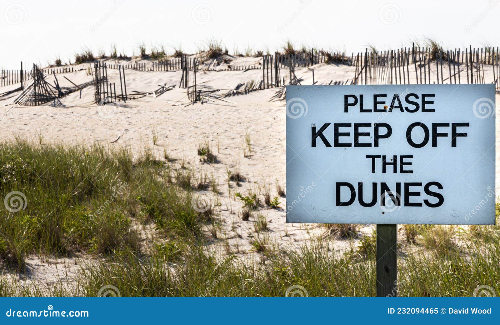 Keep Off the Dunes Sign in Front of Sand Dunes with Broken Fences on ...