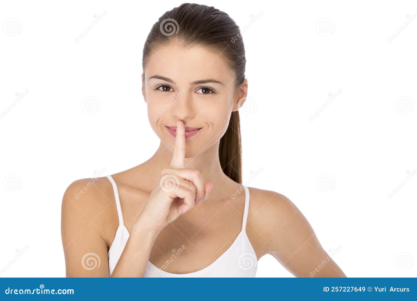 Keep it between Us. Studio Portrait of a Smiling Young Woman Shushing ...