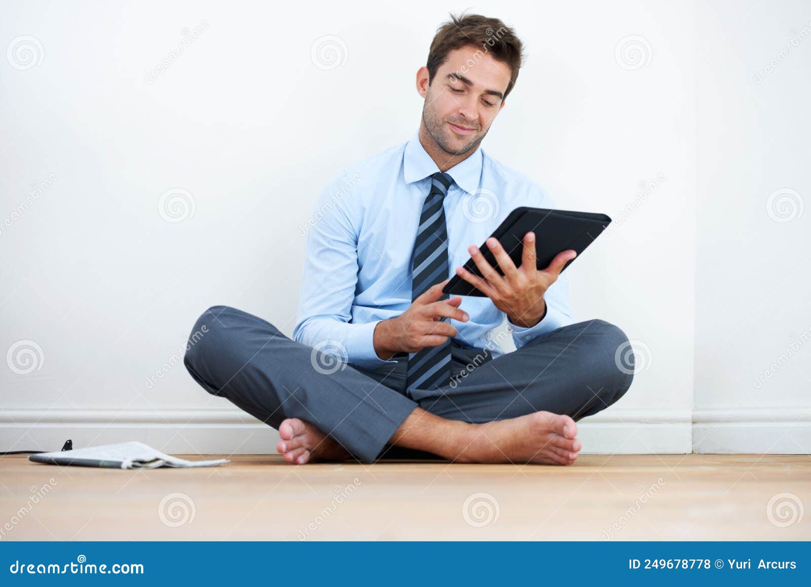 Keeping Current after a Day at Work. a Barefoot Businessman Sitting on ...