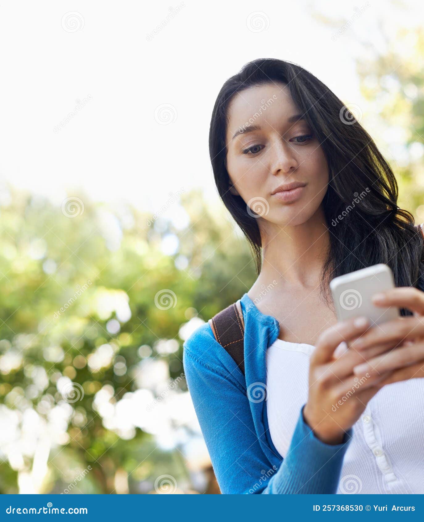 Keeping in Touch while between Classes...Cropped View of a College Student Sending a Text while ...