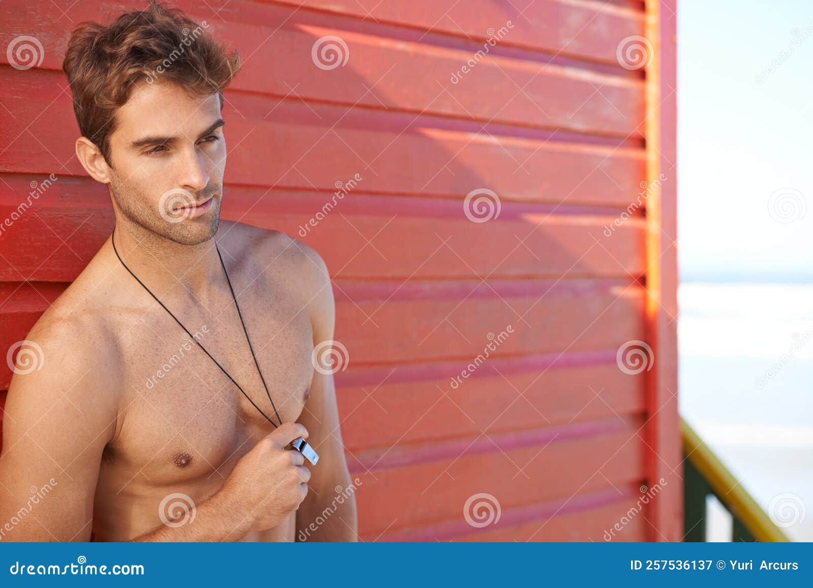 Keeping Watch Over the Waves. a Handsome Young Lifeguard Standing on ...