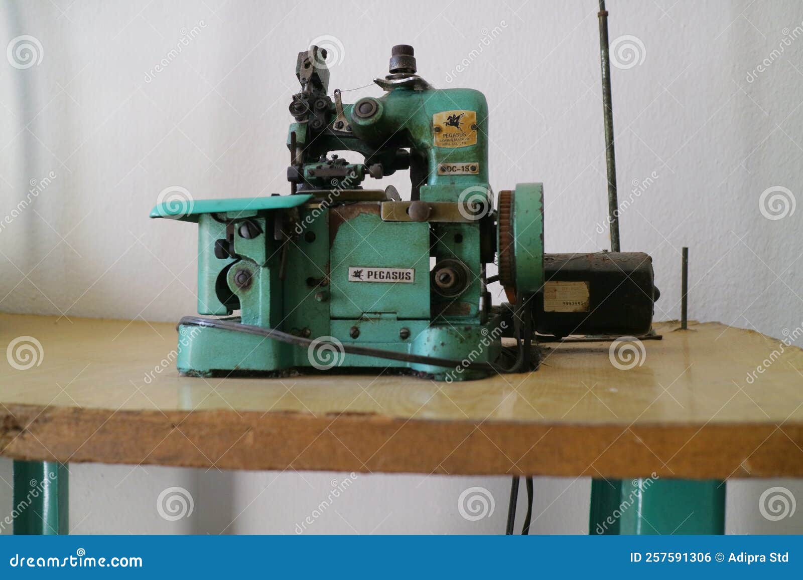 A Green Overlock Machine for Sewing Clothes is Placed on the Table ...