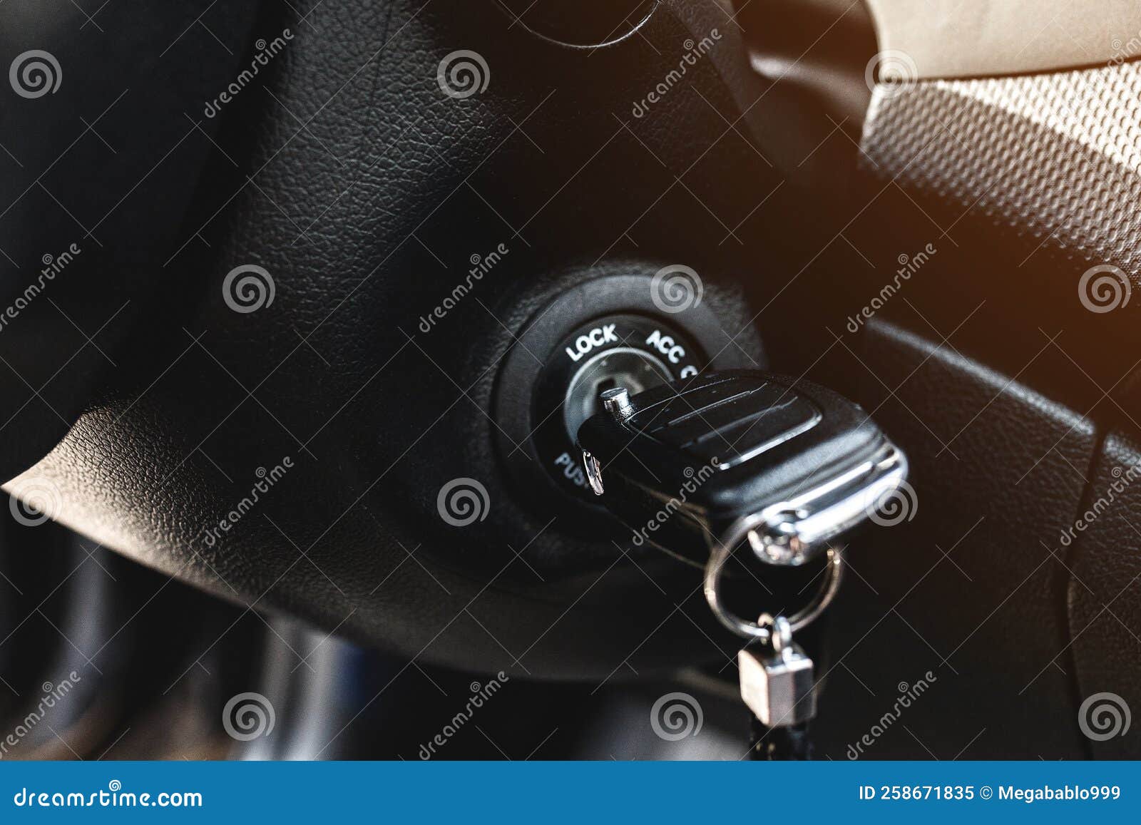 Key in Car Ignition Lock Under the Steering Wheel in a Black Interior ...