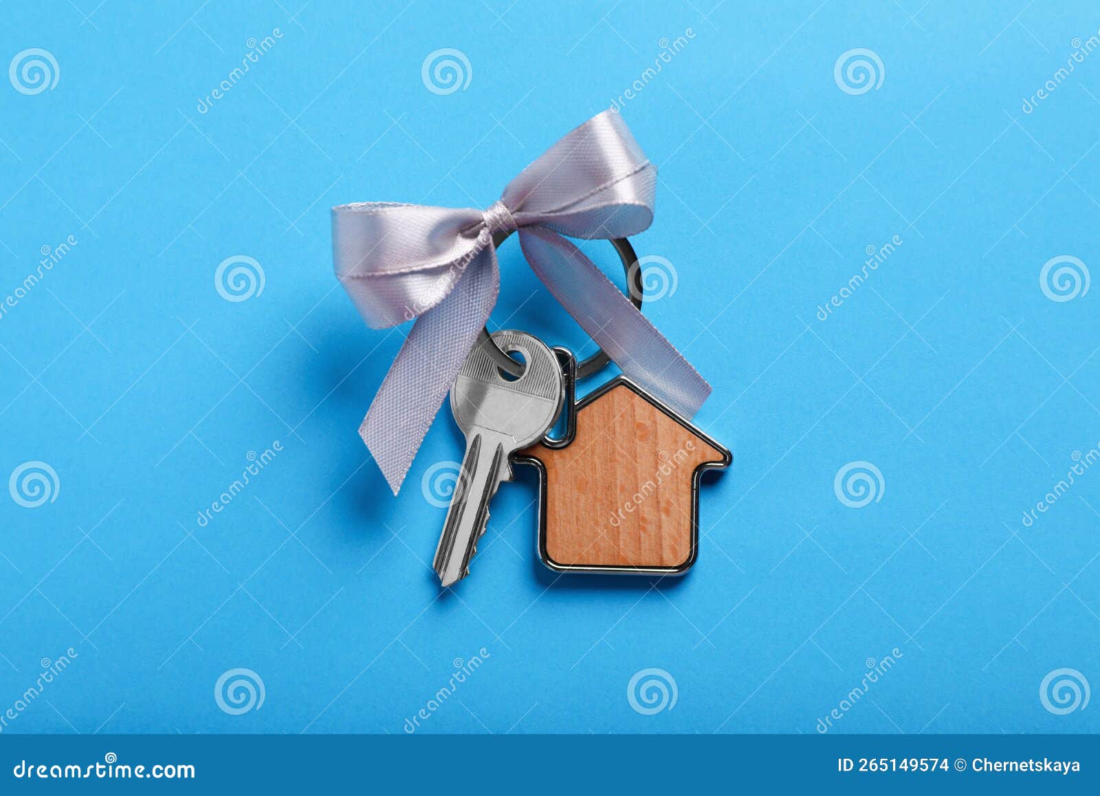 Key with Trinket in Shape of House and Bow on Light Blue Background ...
