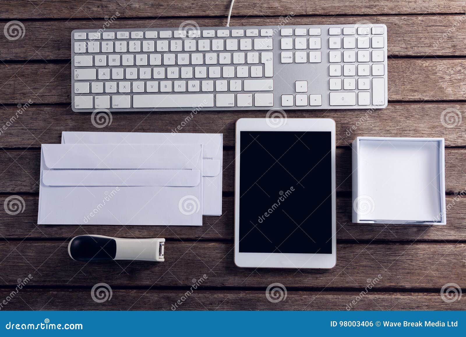Keyboard, Digital Tablet, Envelope, Box and Stapler on Wooden Table ...