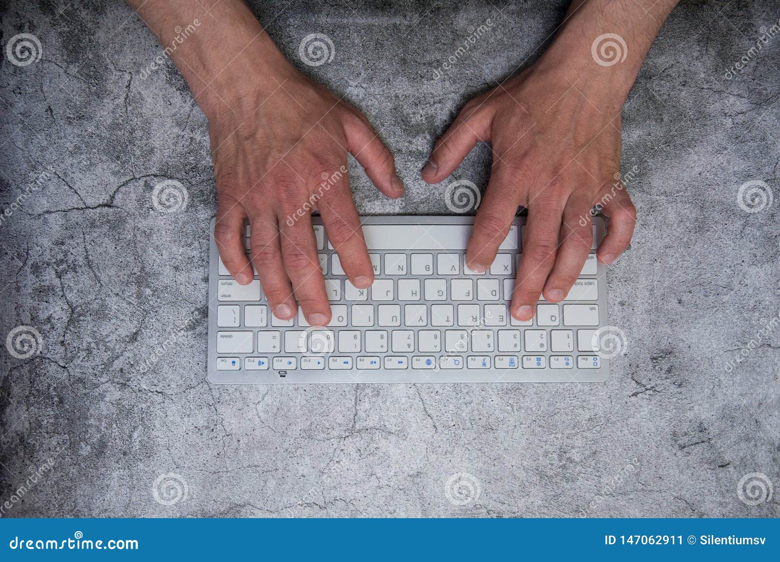 Keyboard with Hands on a Dark Gray Background. Asphalt Concrete ...