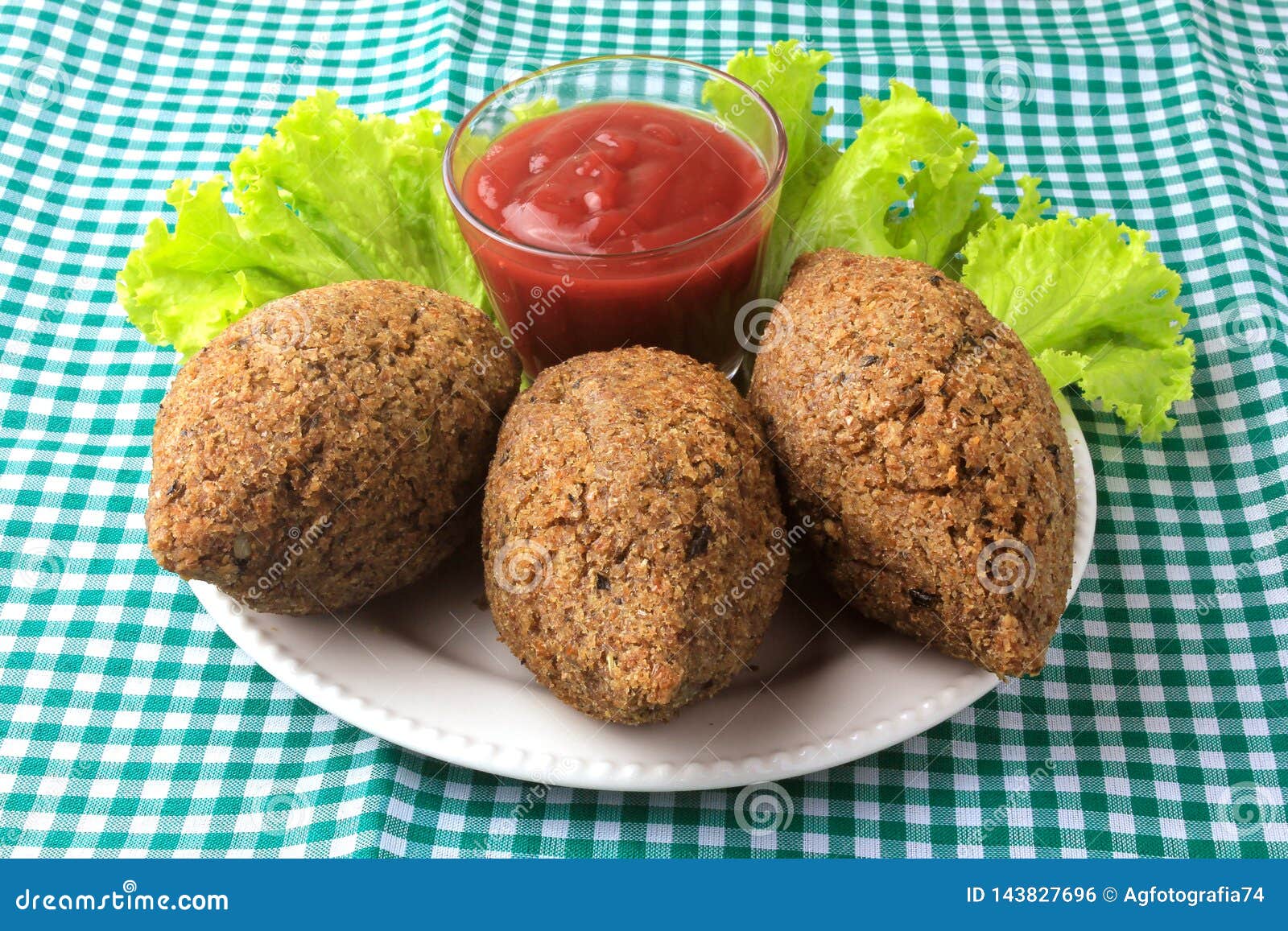 Kibbeh Fried with Tomato Sauce on a Plate, on Table Lined with ...