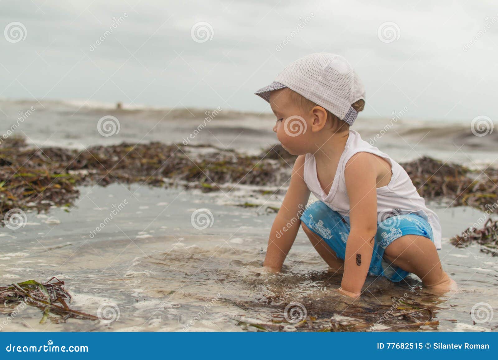 Kid on the Beach Near the Ocean Stock Image - Image of squat, holiday ...