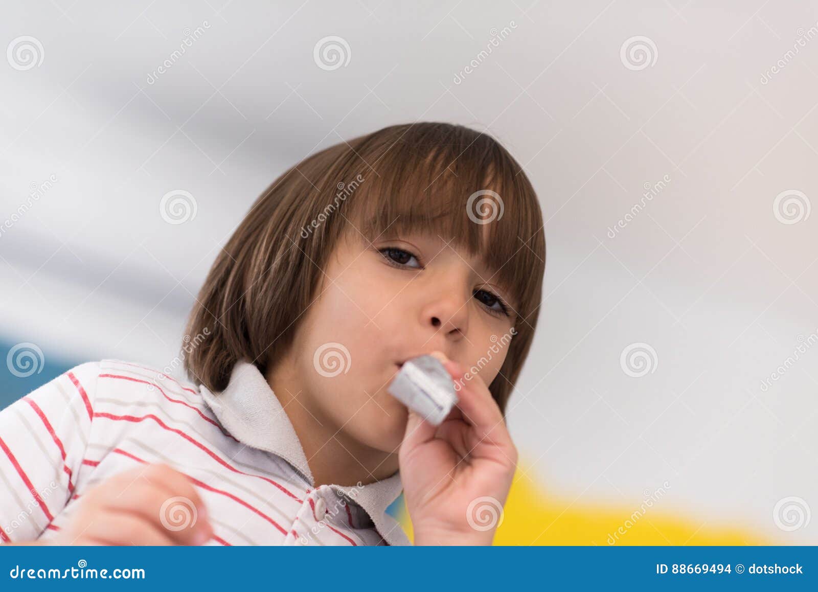Kid blowing a noisemaker stock photo. Image of indoors - 88669494