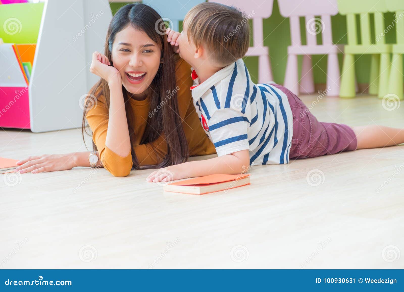 Kid Boy Whisper Teacher while Lay Down on Library Floor at Kindergarten ...