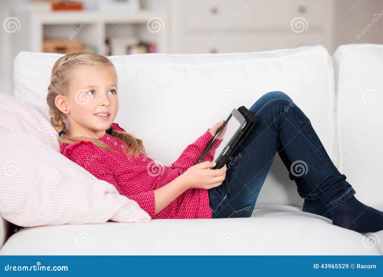 Kid with Digital Pad Lying on Sofa Stock Image - Image of jeans, couch ...