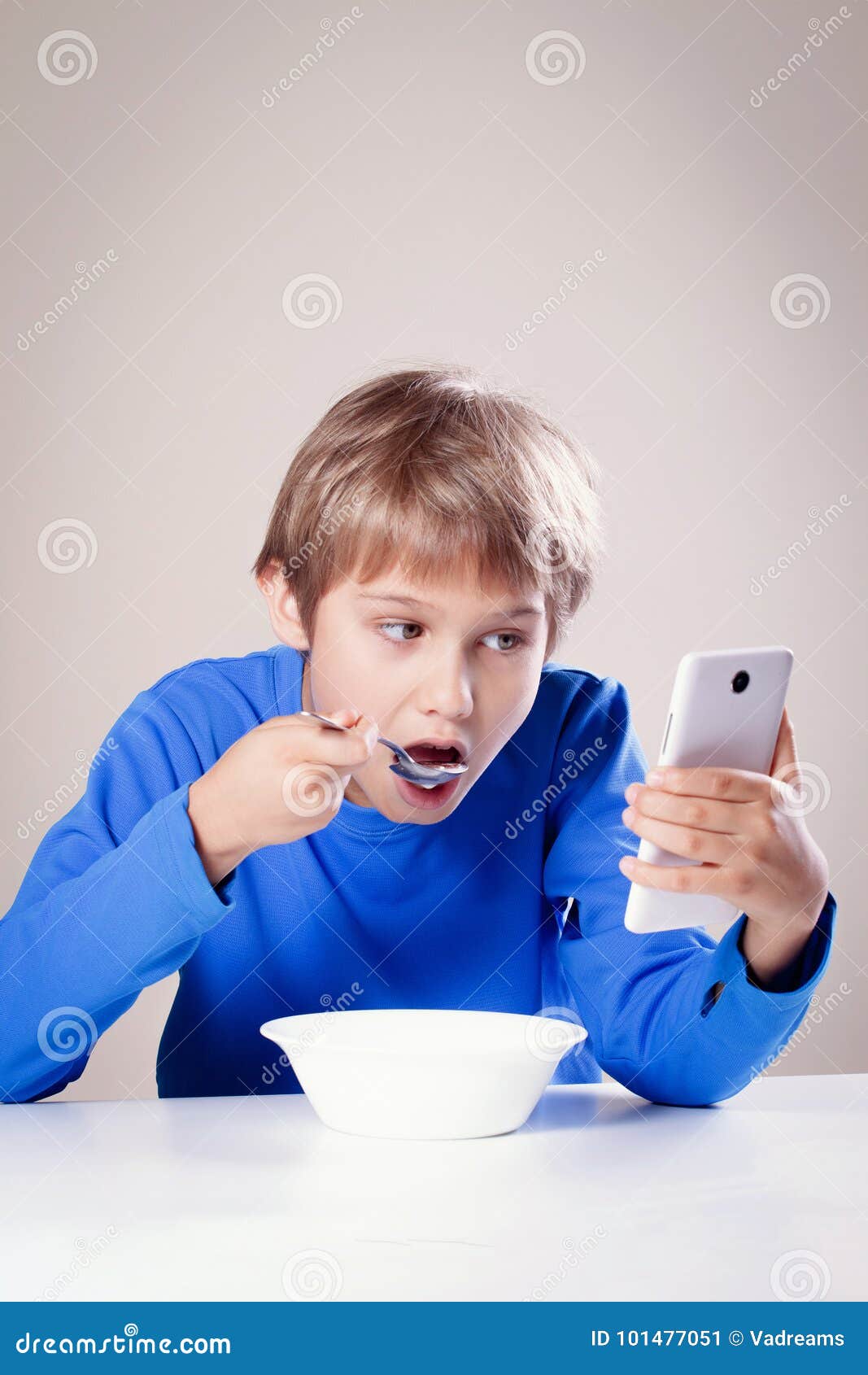 Kid Eating Breakfast Whilst Using Mobile Phone Stock Image - Image of ...