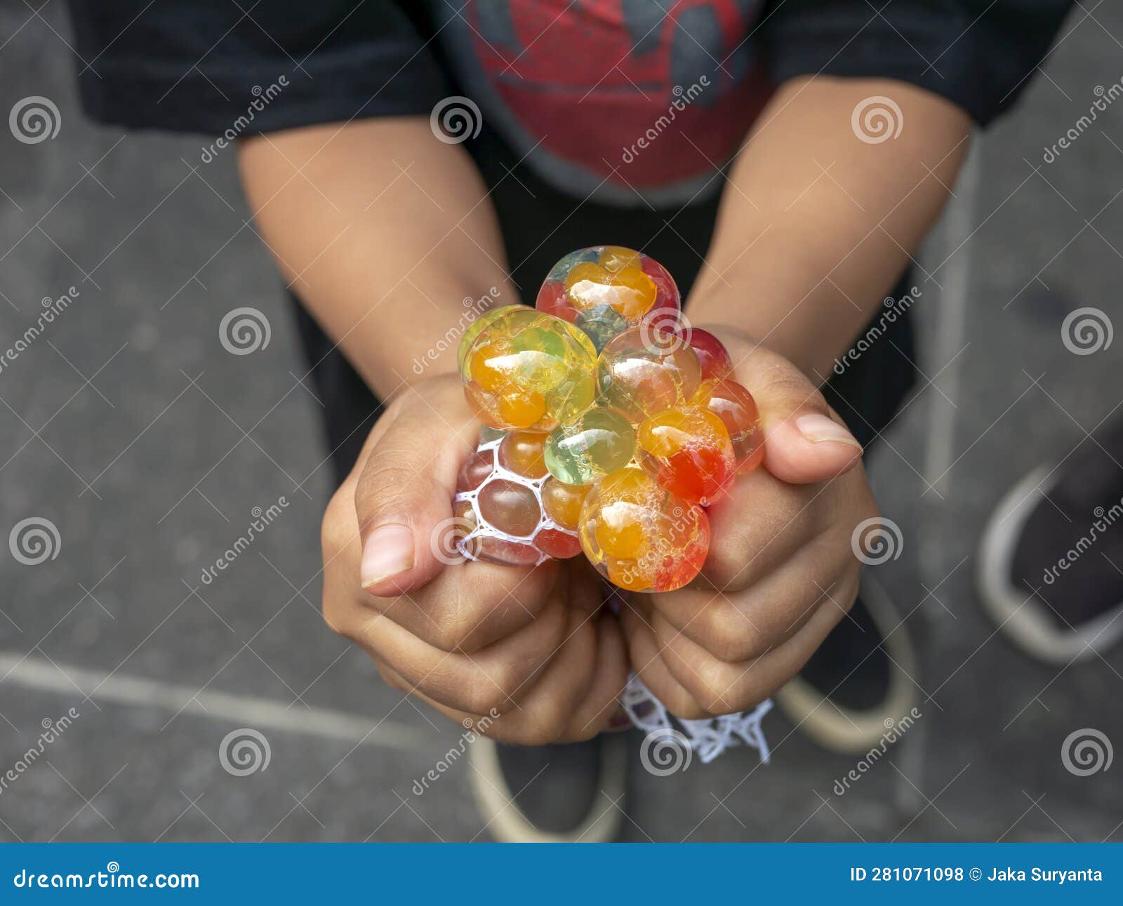 A Kid Holding and Squeezing a Colorful Stress Relief Grape Balls Stock ...