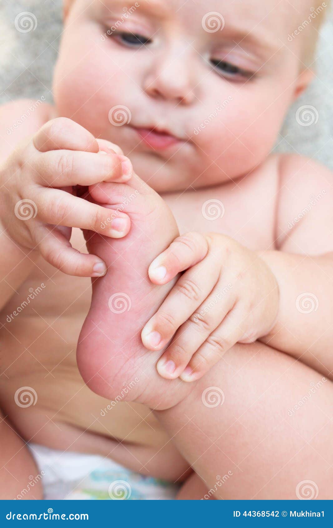 Kid Holds Leg and Looks at Her Stock Photo - Image of attractive ...