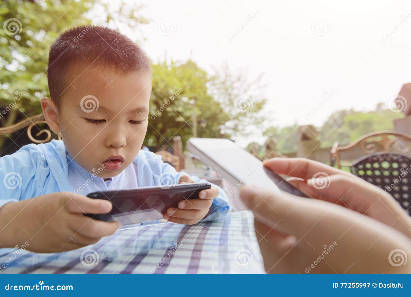 Kid indulge in smartphone stock image. Image of outdoor - 77255997