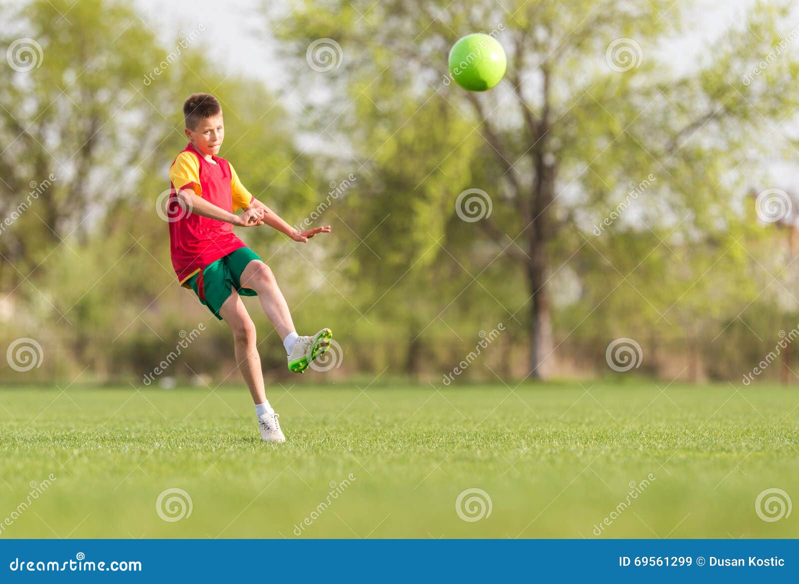 Kid kicking a soccer ball stock image. Image of color - 69561299