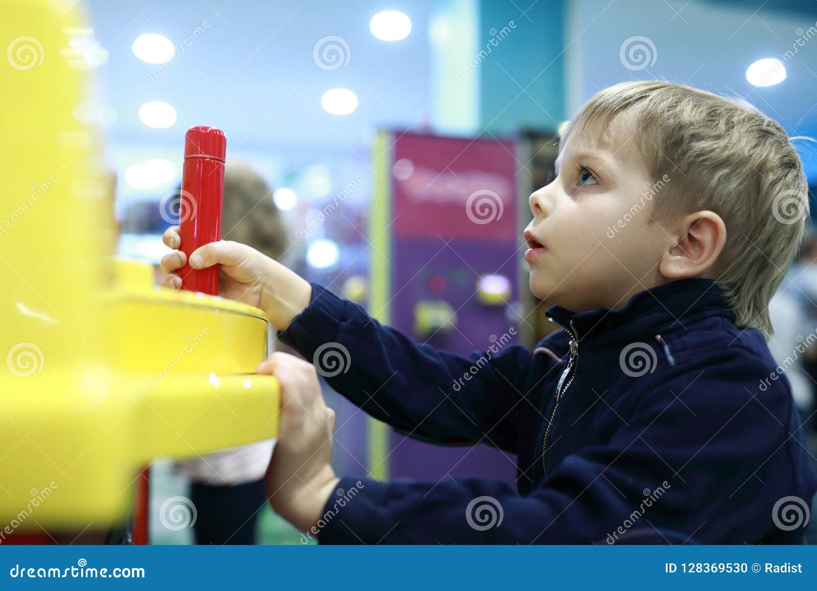Kid playing arcade game stock photo. Image of arcade - 128369530