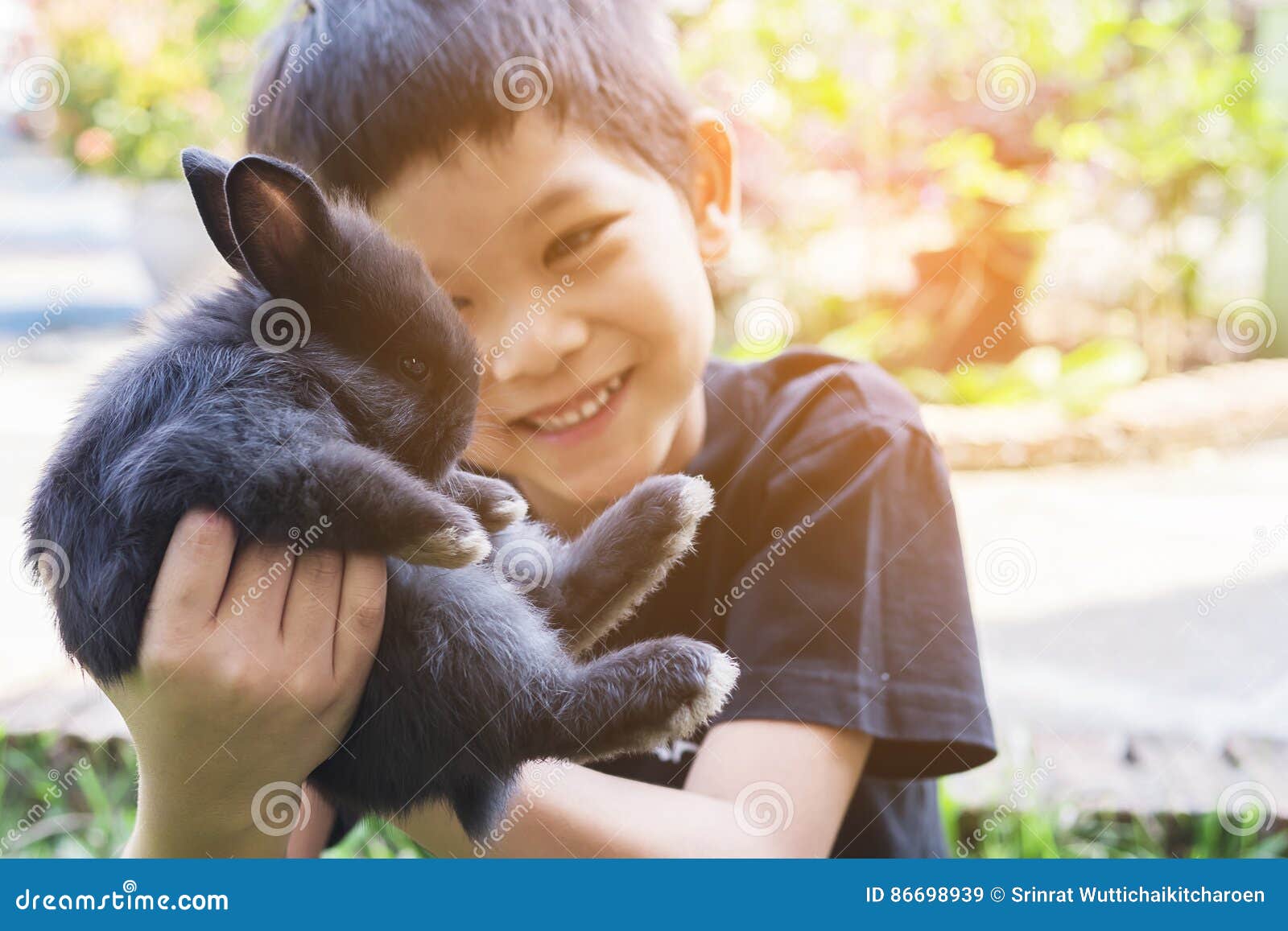 Kid playing baby rabbit stock image. Image of childhood - 86698939