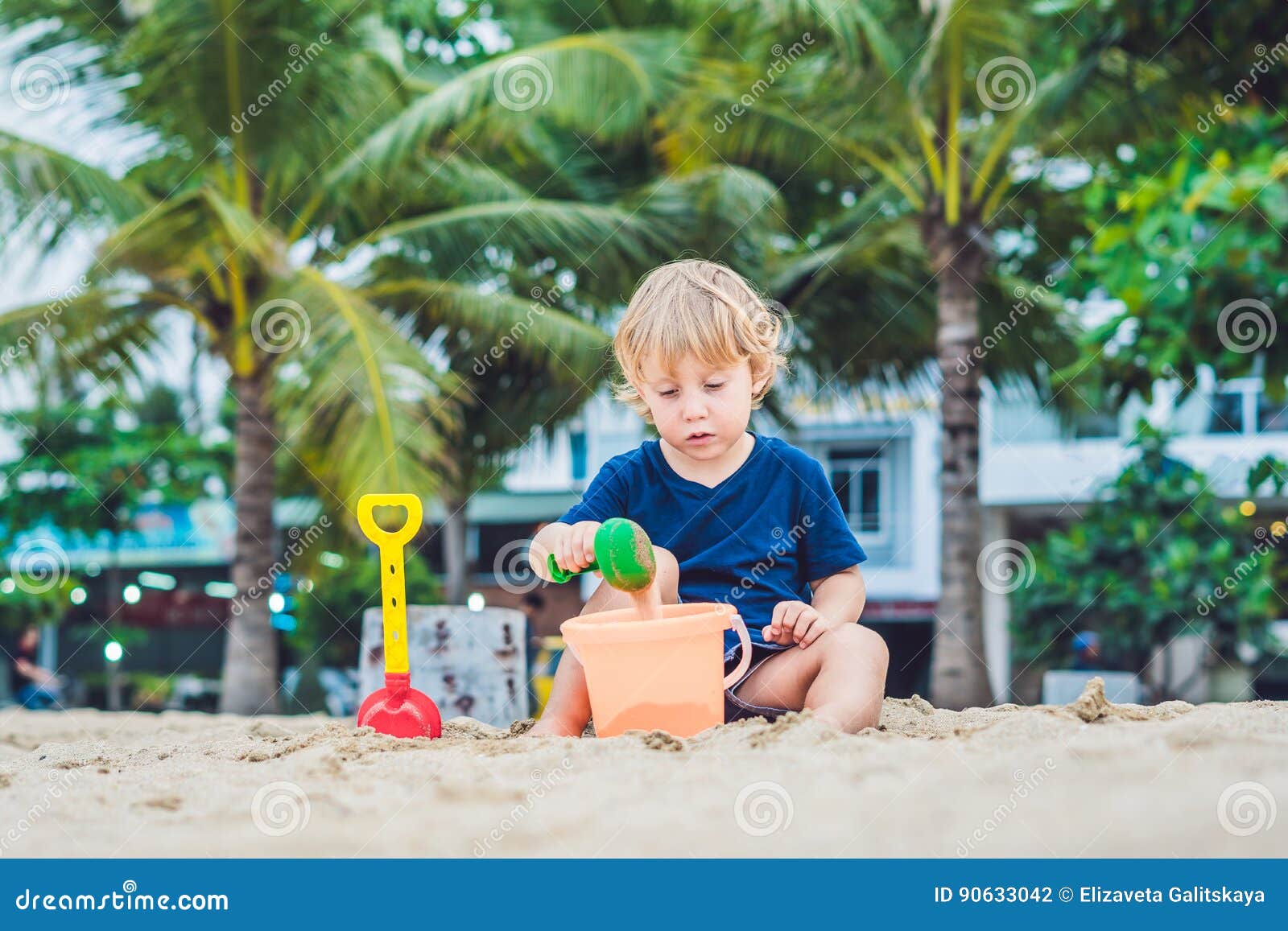 Kid Playing on the Beach with the Children`s Shovel and a Bucket Stock ...