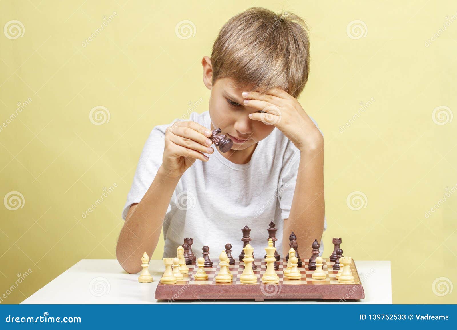 Kid Playing Chess. Boy Looking at Chess Board and Thinking about His ...