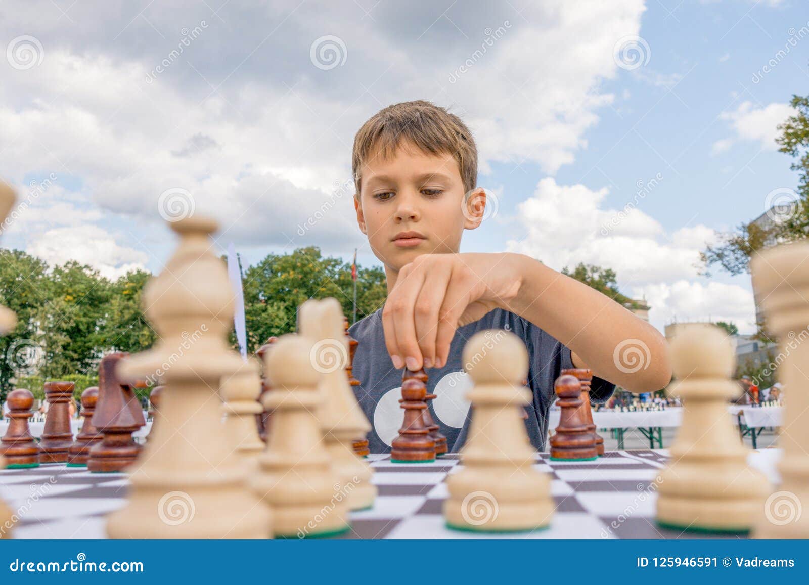 Kid Playing Chess at Chessboard Outdoors. Boy Thinking Chess ...