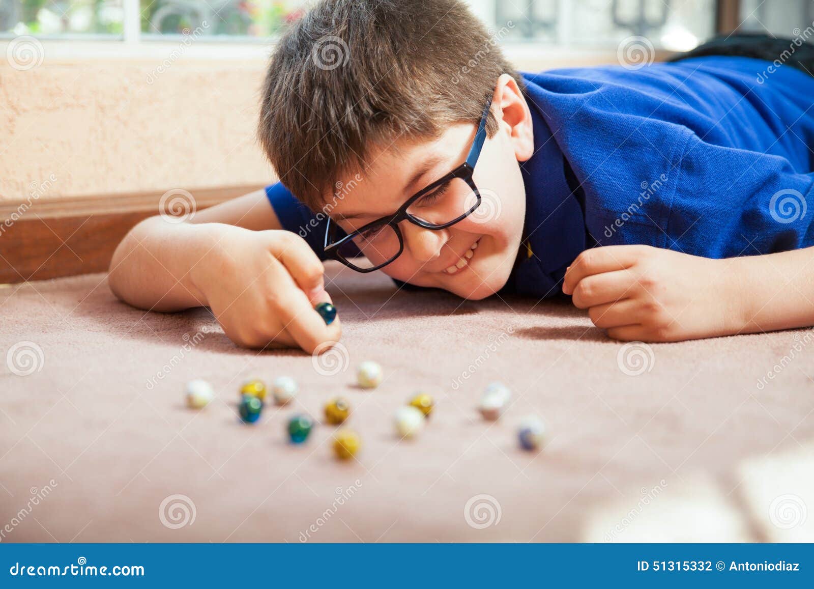 Kid playing with marbles stock photo. Image of male, indoor - 51315332