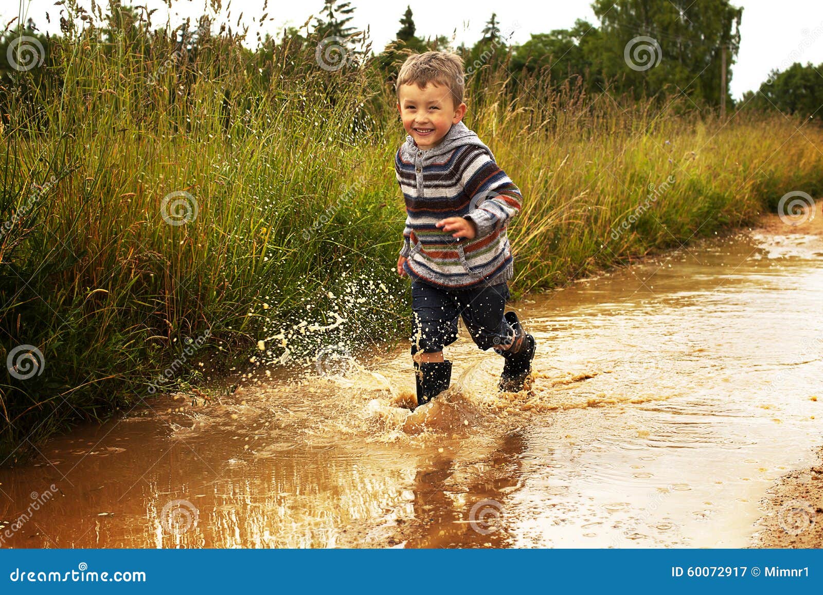 Kid playing in puddle stock image. Image of action, fall - 60072917