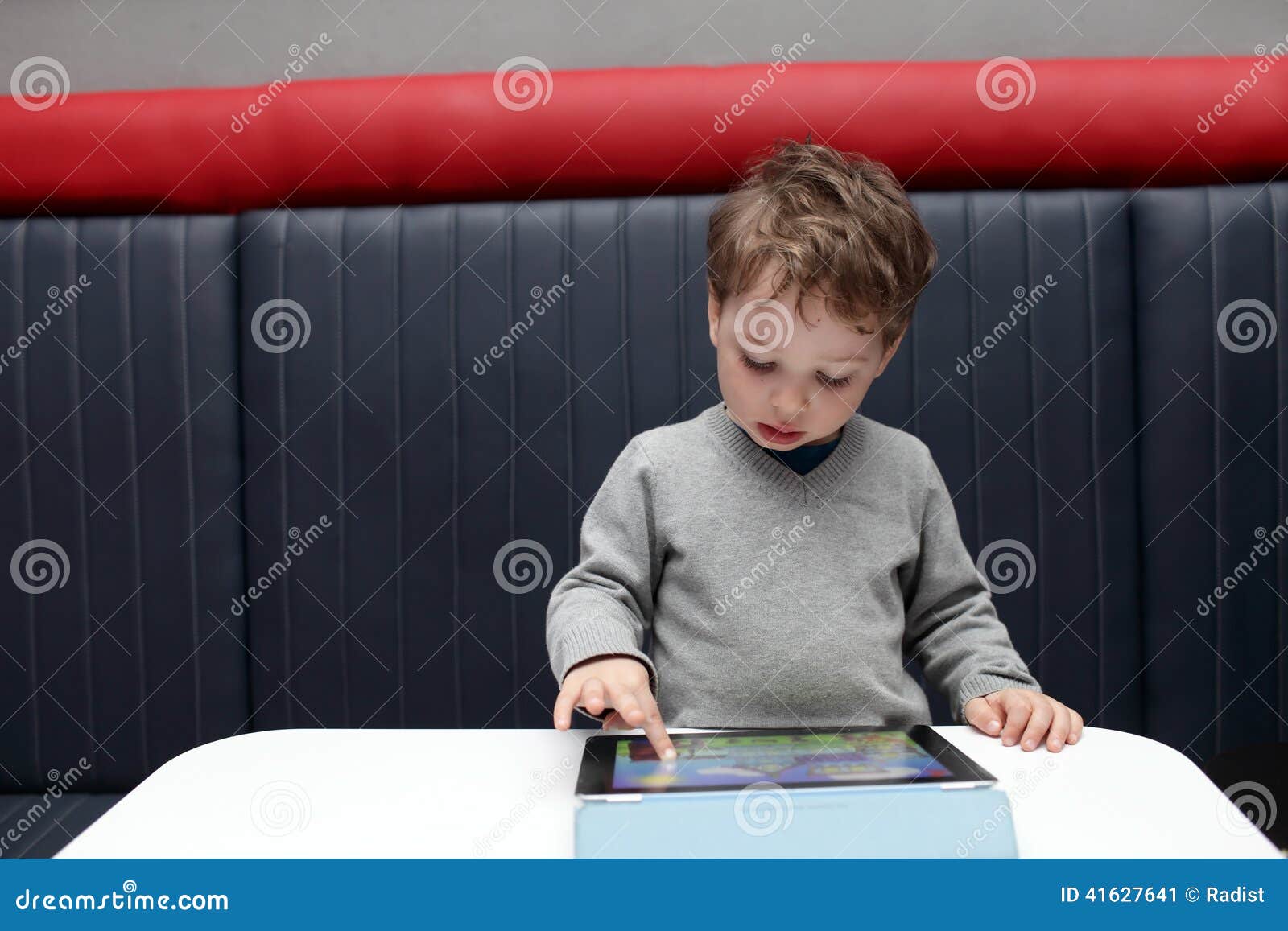 Kid playing with tablet PC stock image. Image of computer - 41627641